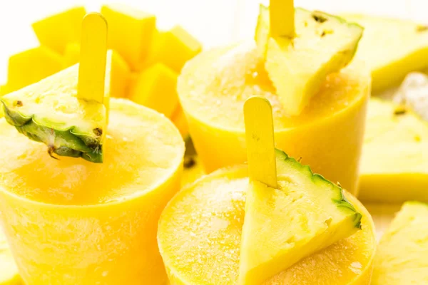 Popsicles made with mango, pineapple and coconut milk. - Stock Image - Everypixel