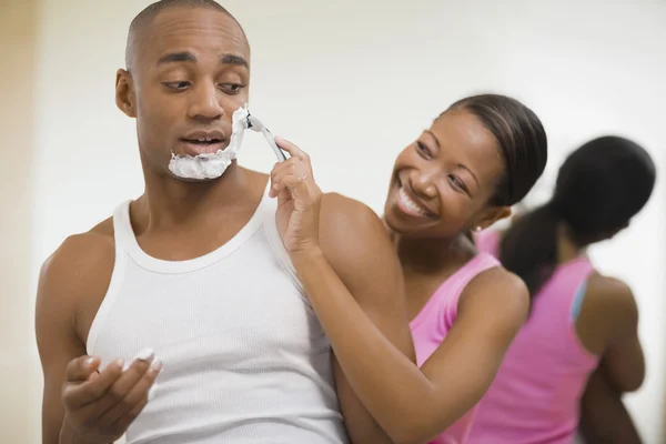 African woman helping husband shave - Stock Image - Everypixel
