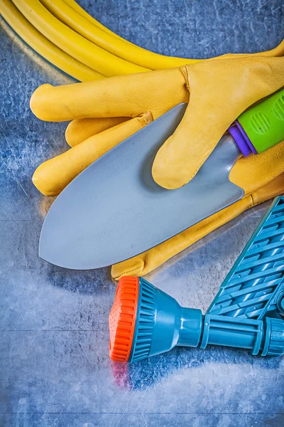 Hose, sprayer, safety gloves and spade - Stock Image - Everypixel