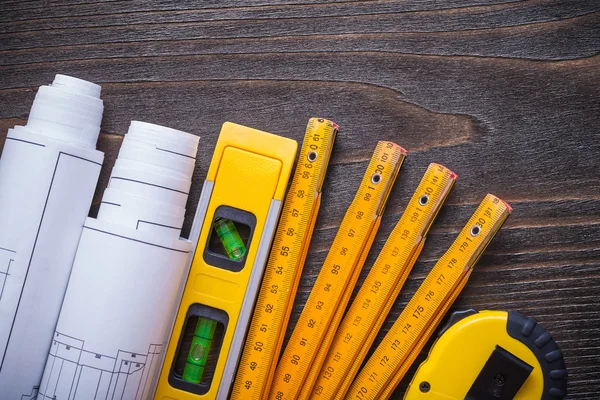 blueprint rolls, construction level and wooden meter - Stock Image ...