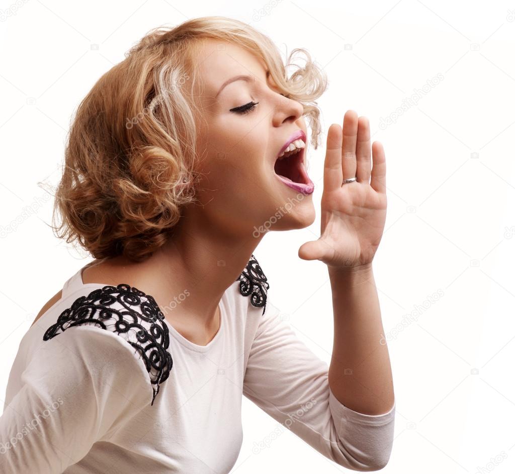 Young blonde woman shout and scream using her hands as tube, studio ...