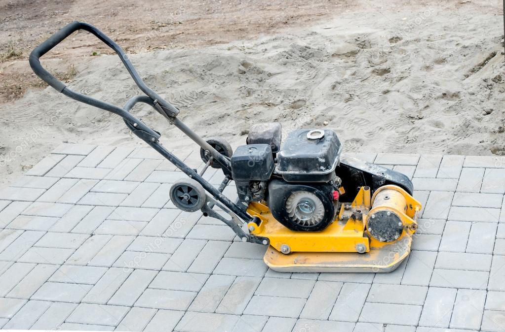 Small yellow compactor standing on new gray pavement Stock Photo by ...