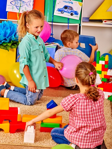 Group children game blocks on floor . Stock Photo by ©poznyakov 109223146