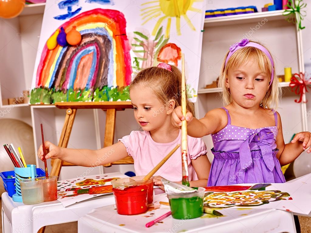 Child painting at easel. — Stock Photo © poznyakov #75140053