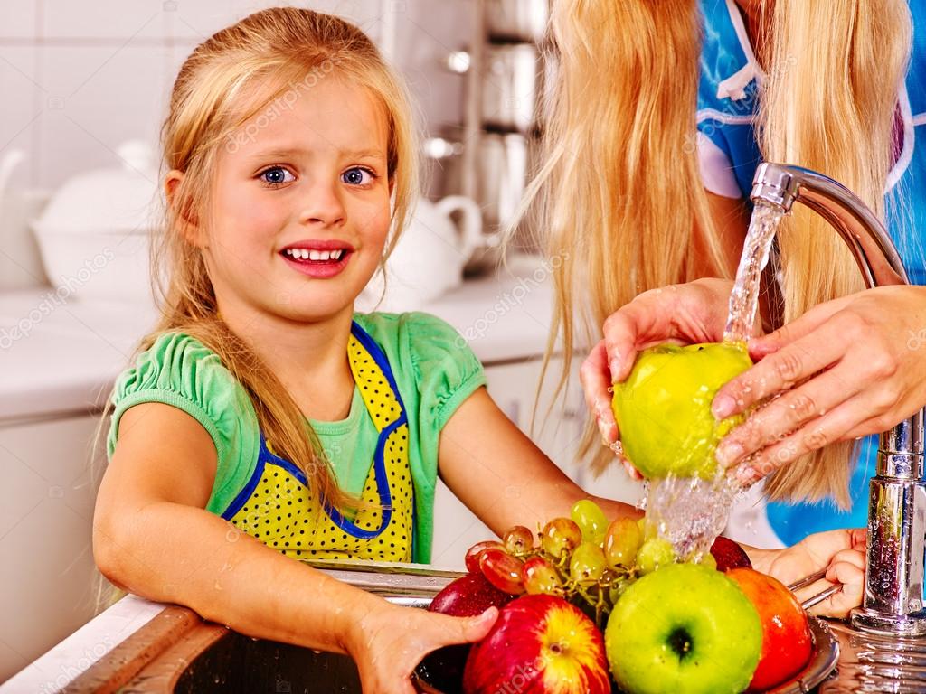 Niños lavando fruta en la cocina . — Foto de stock #76107923 © poznyakov