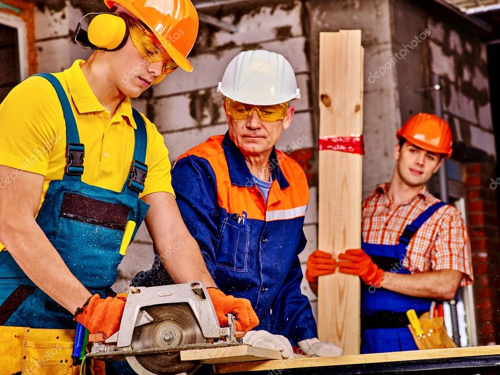 Group people builder with circular saw Stock Photo by ©poznyakov 78184796