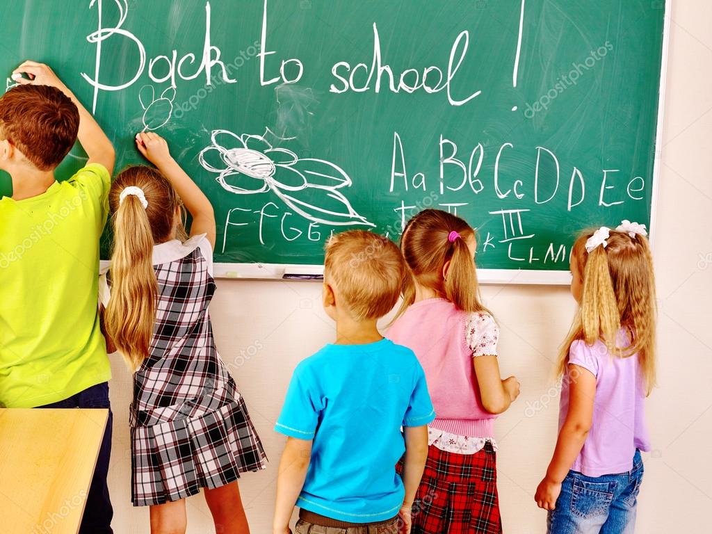 Children writing on blackboard. Stock Photo by ©poznyakov 79878618