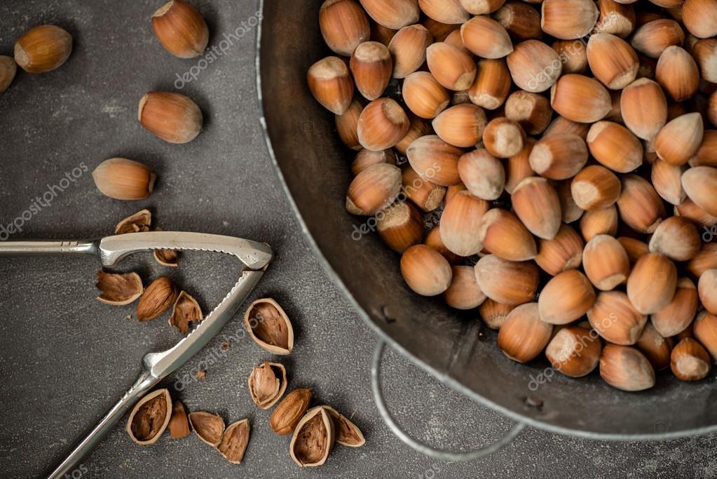 Cracking raw hazelnuts Stock Photo by ©Shebeko 111617392