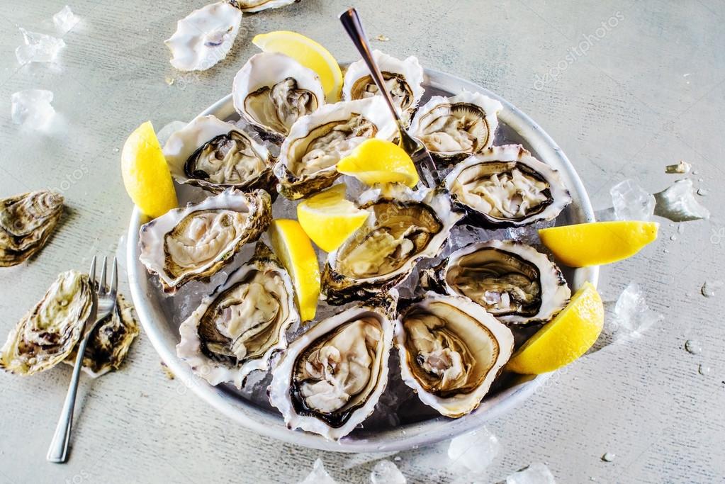 Opened Oysters with lemon Stock Photo by ©Shebeko 86600760