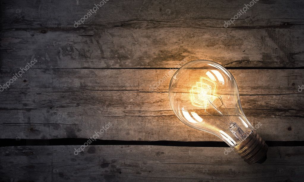 Light bulb on wooden surface Stock Photo by ©SergeyNivens 111611316