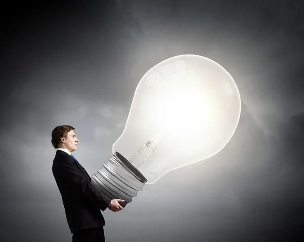Man carrying a light bulb Stock Photos, Royalty Free Man carrying a ...