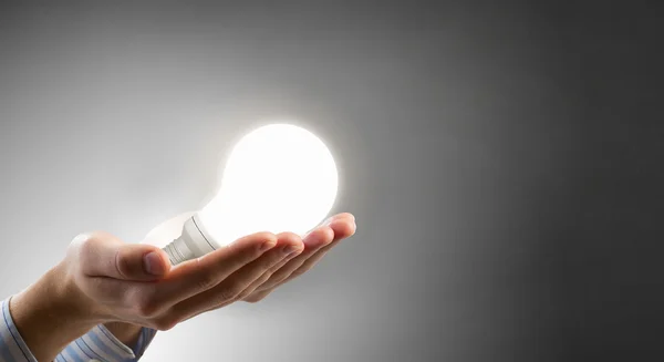 Light bulb in hand - Stock Image - Everypixel