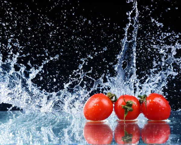 Studio shot with freeze motion of cherry tomatoes in water splash on ...