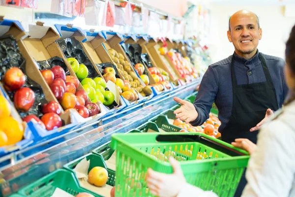 Man offering customer fruits - Stock Image - Everypixel