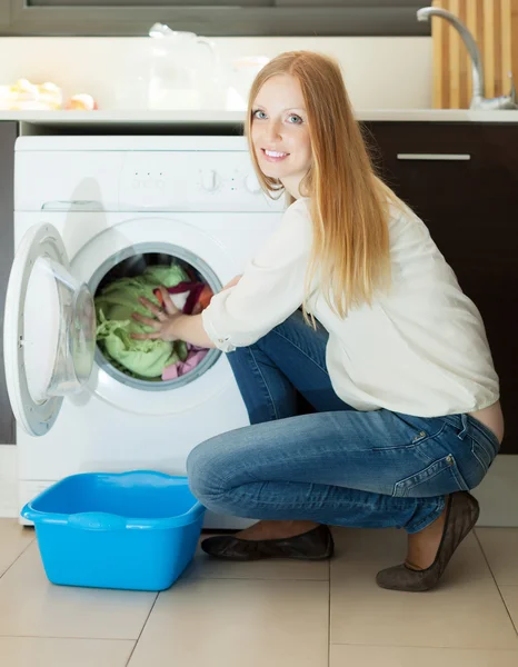 Long-haired woman using washing machine at home - Stock Image - Everypixel