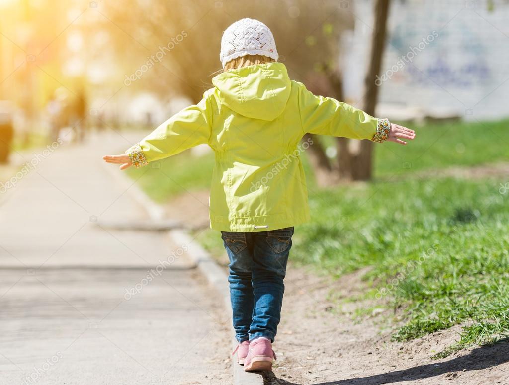 Niña En Abrigo Amarillo Caminando En El Parque Fotografía De Stock