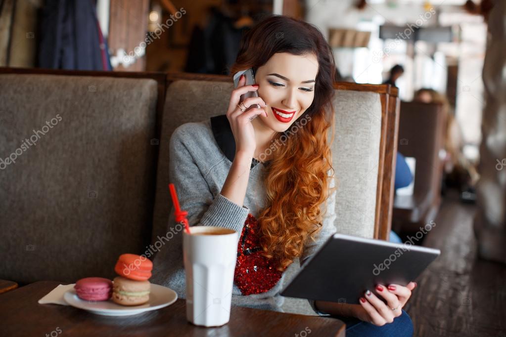 Girl in a cafe talking on a cell phone Stock Photo by ©golyak 103248308