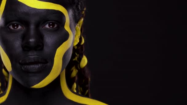 Face art. Woman with black and yellow body paint. Young african girl ...