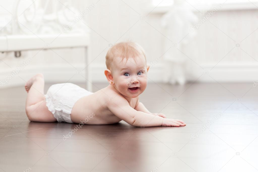 Happy seven month old baby girl crawling on a hardwood floor Stock ...