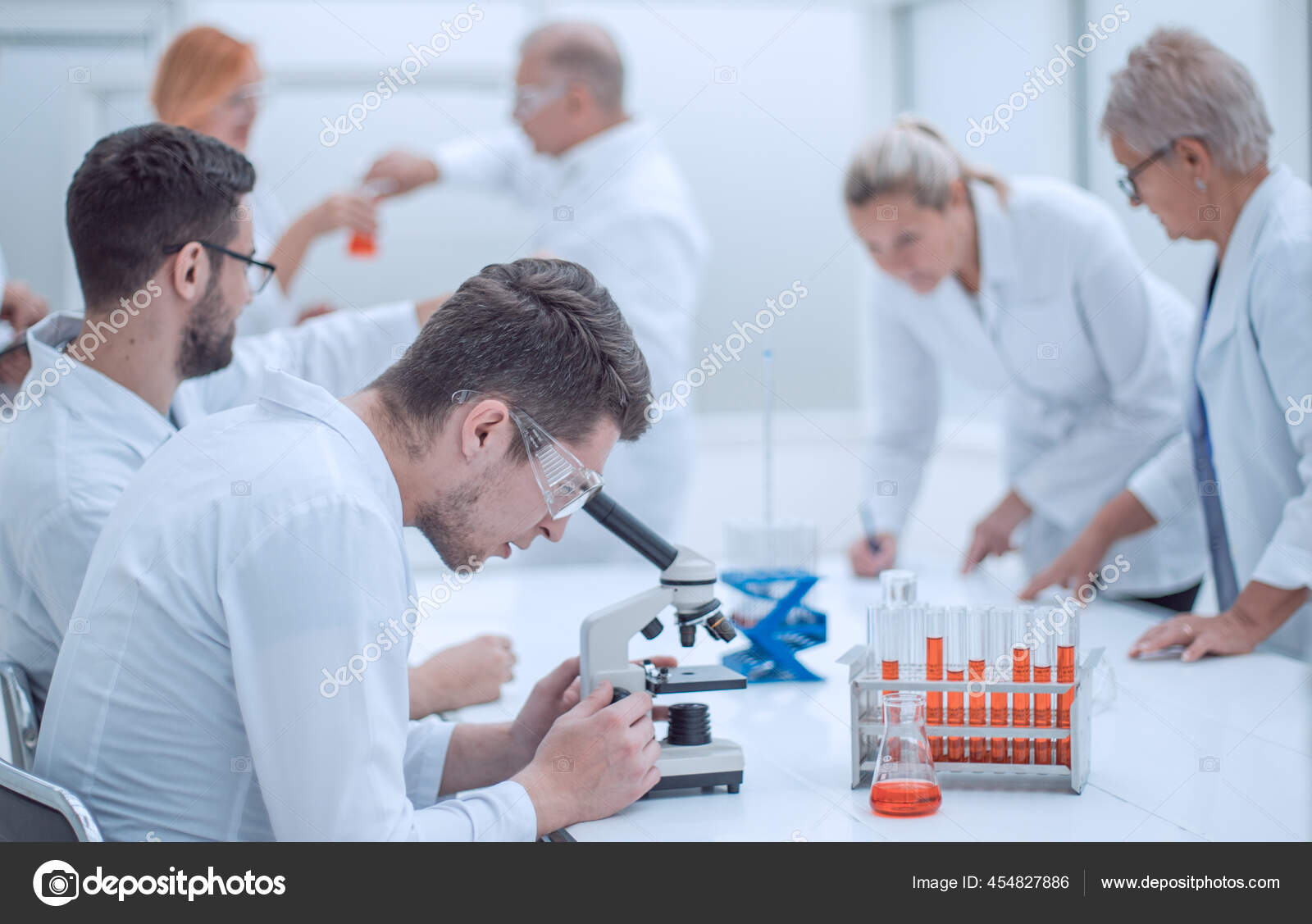 Grupo de científicos que utilizan microscopios para estudiar la sangre. — Foto de stock ...