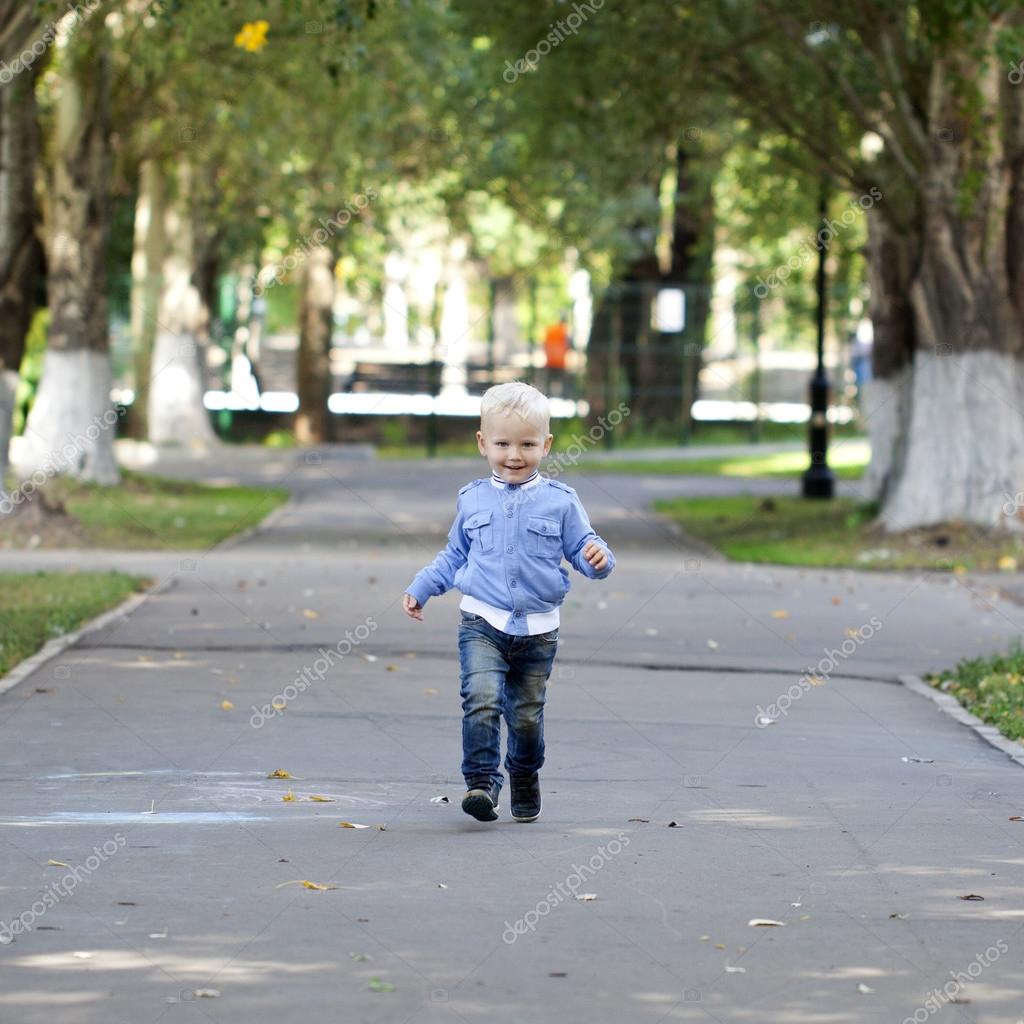 Little boy running on the sidewalk in the summer park Stock Photo by ...