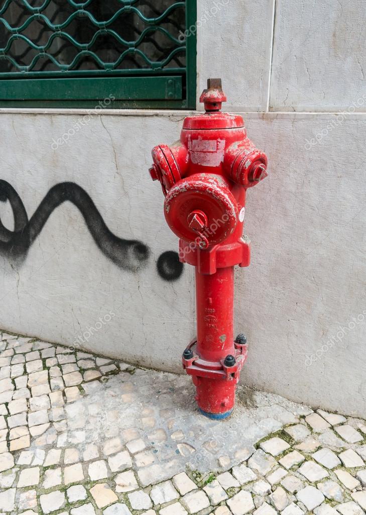 Weathered red fire hydrant near a cement wall — Stock Photo ...
