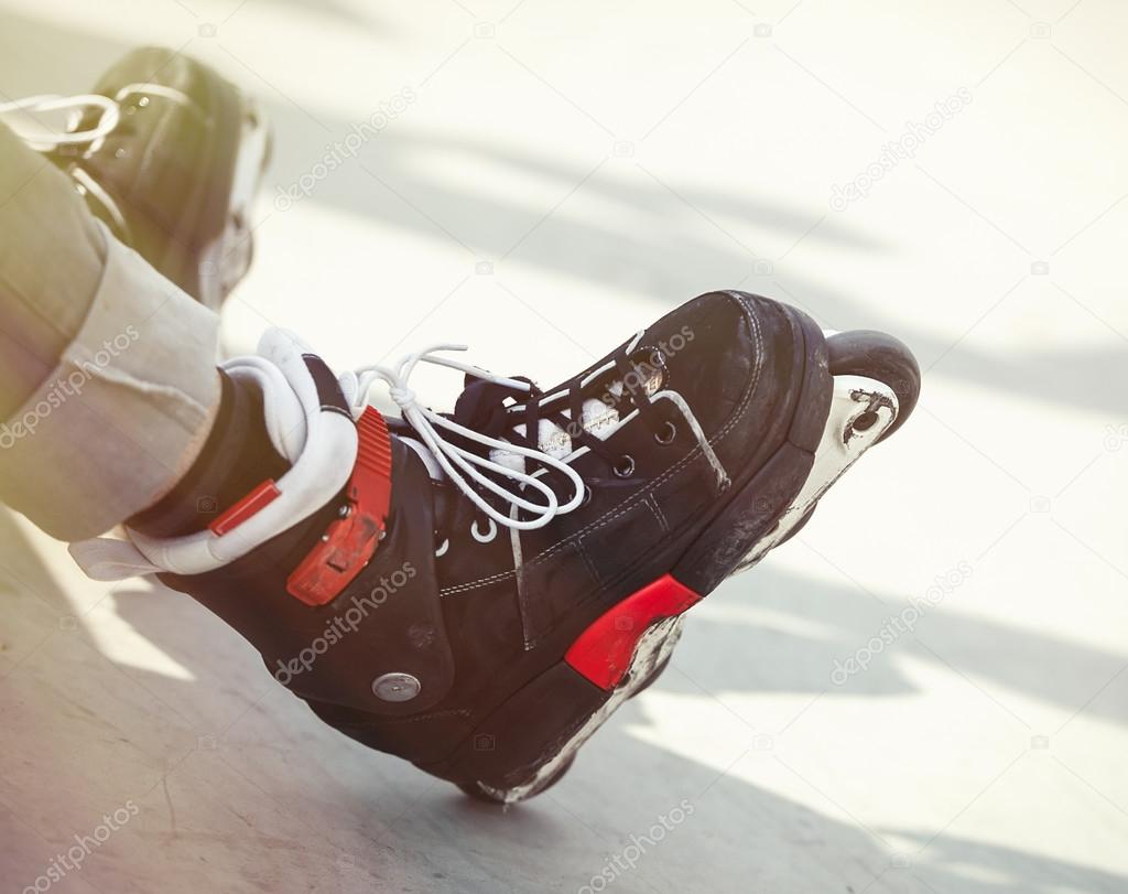 Aggressive inline rollerblader sitting on ramp in skatepark — Stock ...
