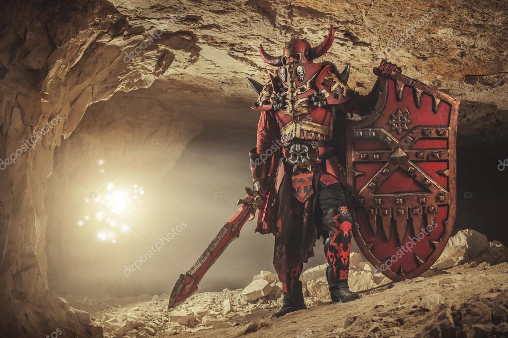 Powerful knight in heavy armor with the sword and shield — Stock Photo ...