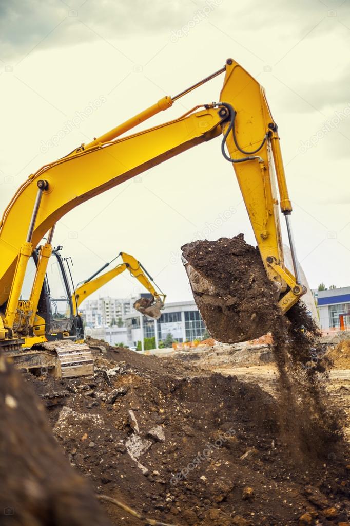 Two excavators are digging earth on the construction site. — Stock ...