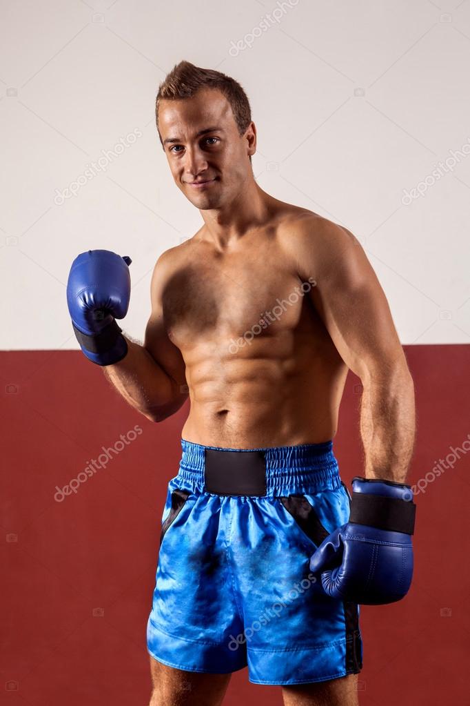 Powerful smiling boxer is showing his muscles. — Stock Photo © bigdan ...