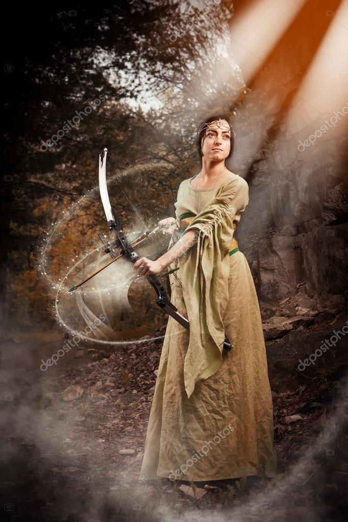 Elf woman with the magic bow on the autumn forest background. Stock ...