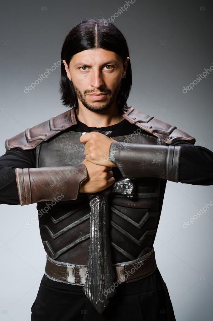Angry knight with sword against dark background Stock Photo by ©Elnur ...