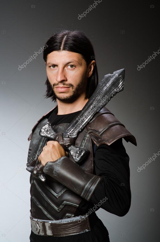 Angry knight with sword against dark background Stock Photo by ©Elnur ...
