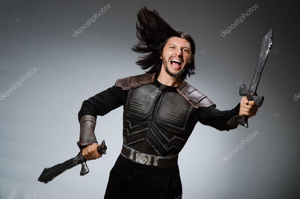 Angry knight with sword against dark background Stock Photo by ©Elnur ...