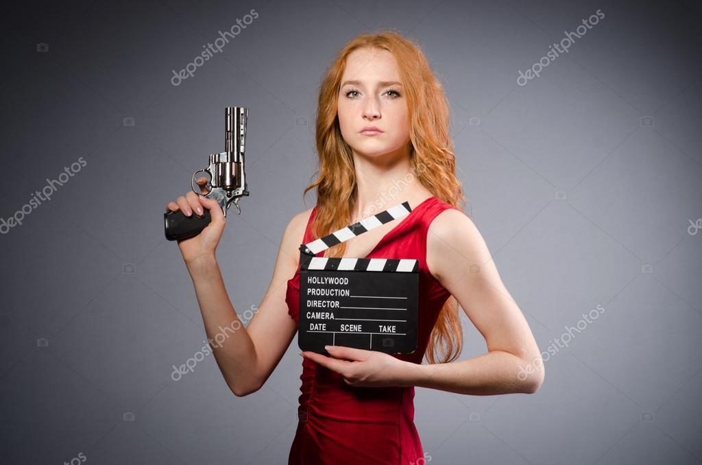 Pretty young girl in red dress with gun isolated on grey — Stock Photo ...