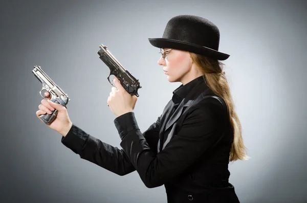 Female spy with weapon against gray Stock Photo by ©Elnur_ 90168358