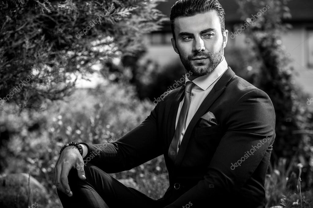 Elegant handsome man in classical costume pose outdoor. Black-white ...