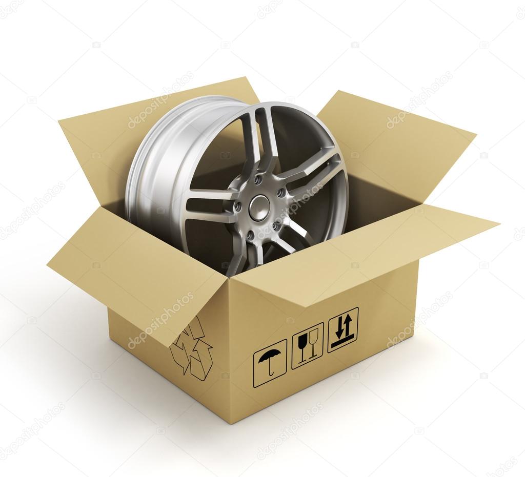 Open cardboard box with car rims on white background. Online sto ...