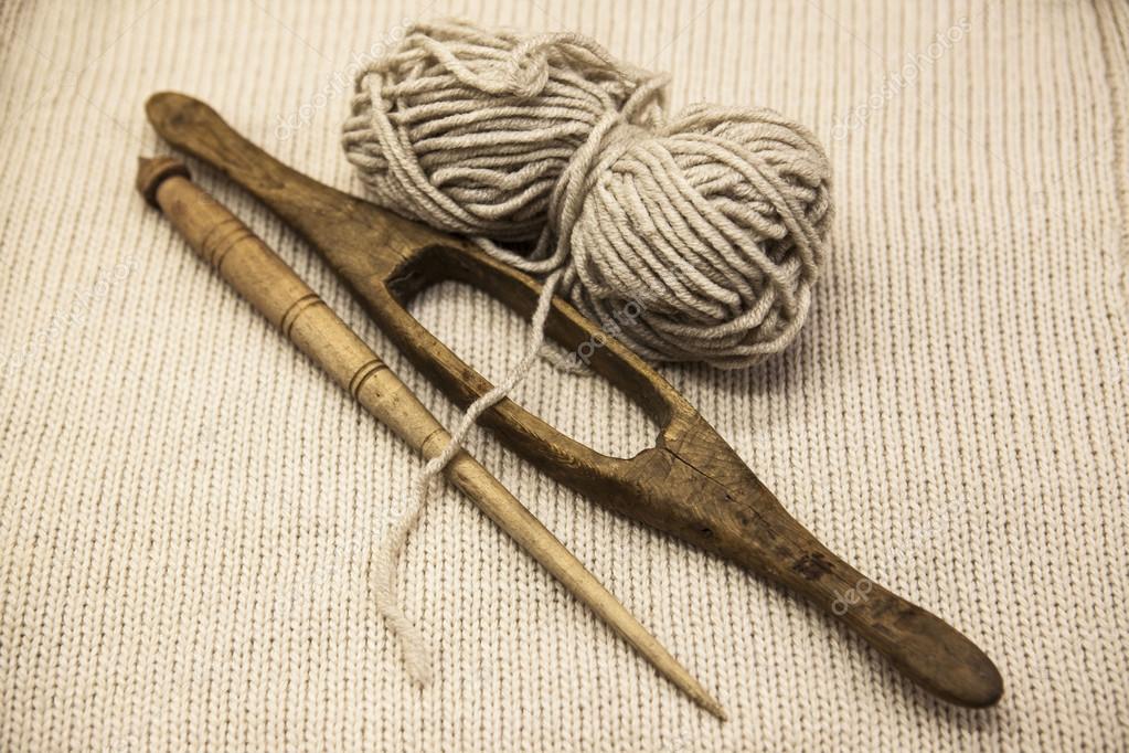 Two old wooden spindle with a ball of wool thread for the manufacture ...