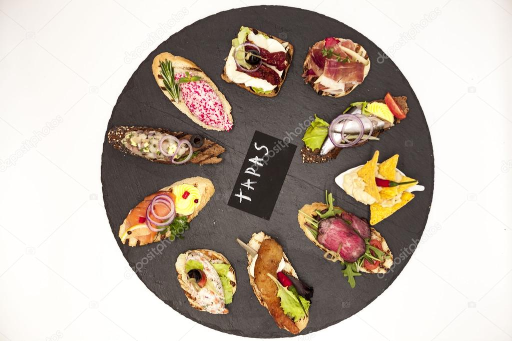 Set de tapas españolas en el plato de piedra sobre fondo blanco. Gran ...