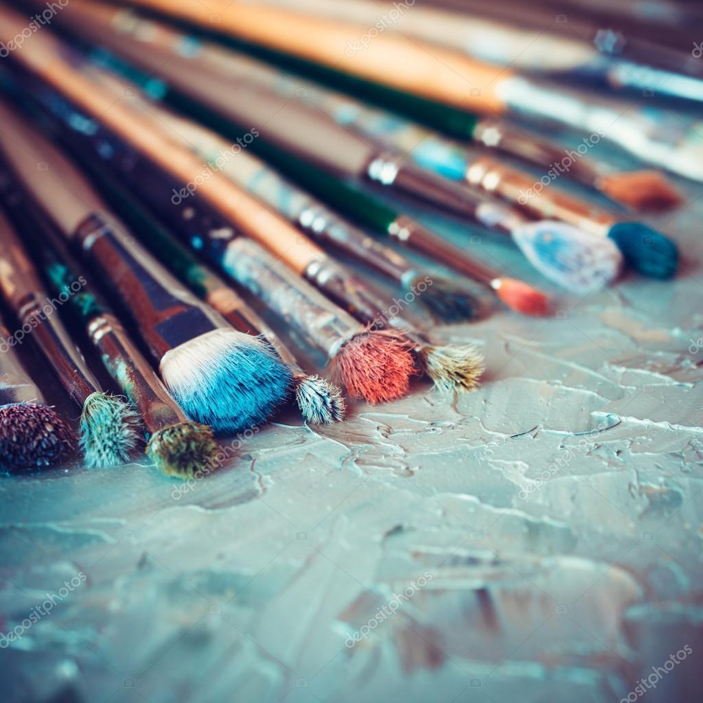 Artistic paintbrushes on artist canvas covered with oil paints — Stock ...