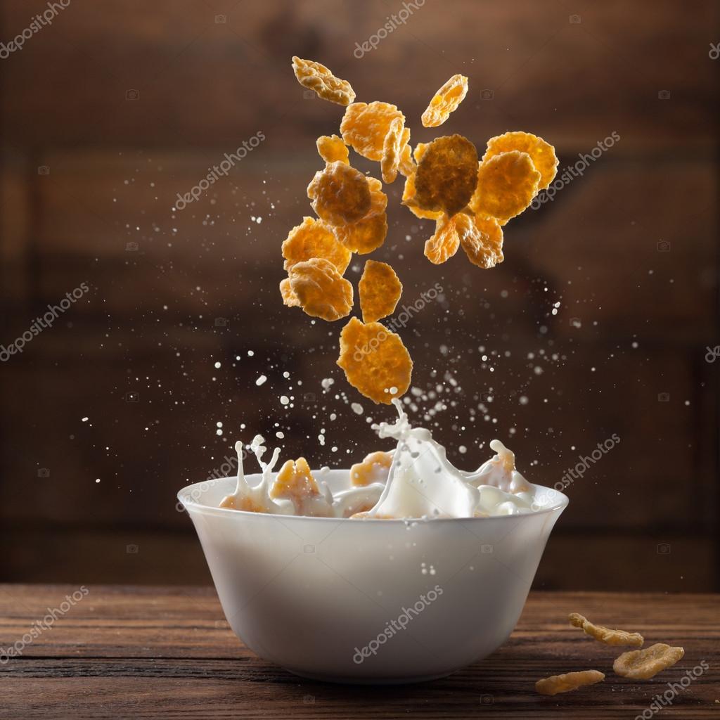 Falling corn flakes with milk splash on wood Stock Photo by ©artjazz ...
