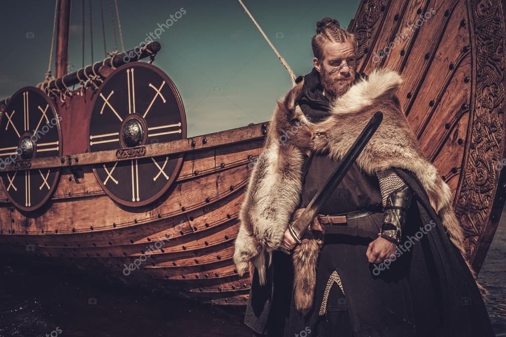 Viking warrior with sword standing near Drakkar — Stock Photo © nejron ...