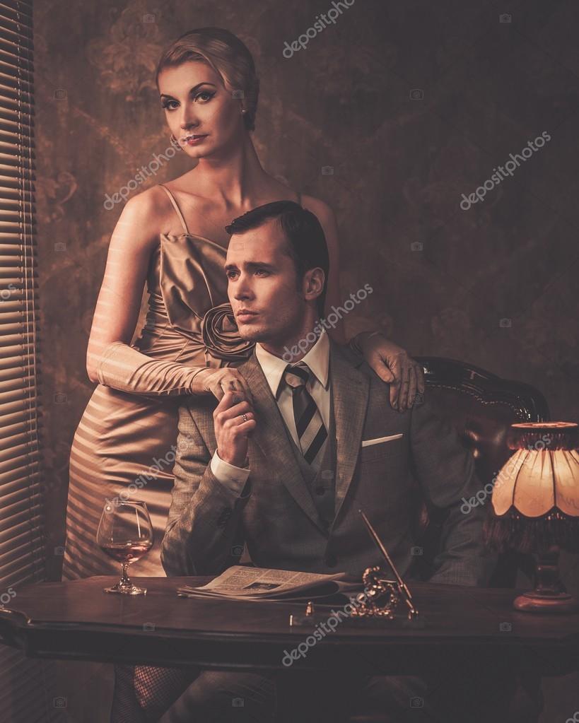 Well-dressed couple sitting behind table Stock Photo by ©nejron 56717835