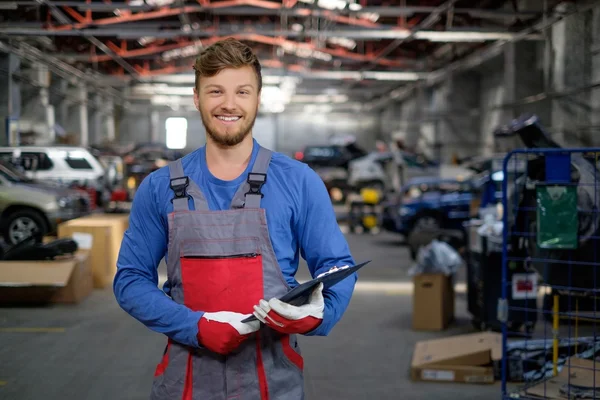 Cheerful serviceman in a car workshop Stock Photo by ©nejron 91820782