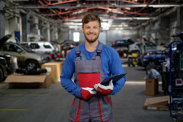 Cheerful serviceman in a car workshop Stock Photo by ©nejron 91820782
