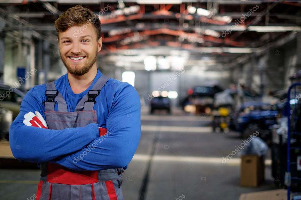 Cheerful serviceman in a car workshop Stock Photo by ©nejron 91820782