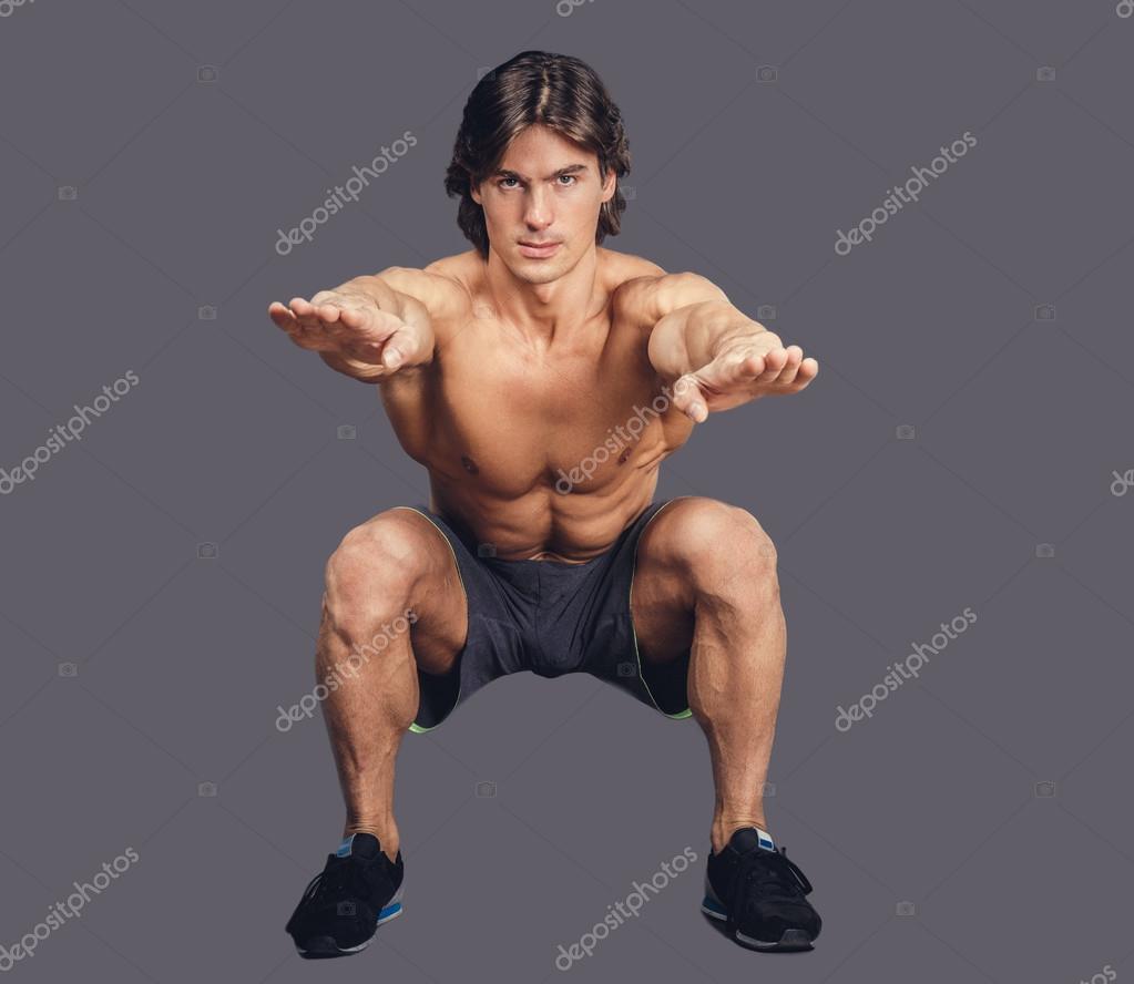 Muscular male doing squats Stock Photo by ©fxquadro 117744272