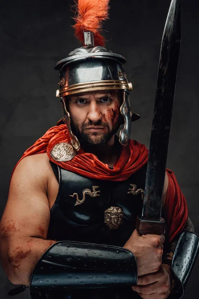 Roman killer posing with swords near his face in dark background Stock ...