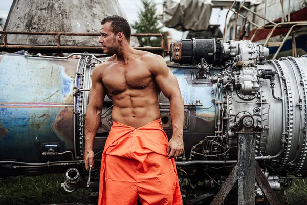 Mechanic macho with muscular build in orange clothing - Stock Image ...